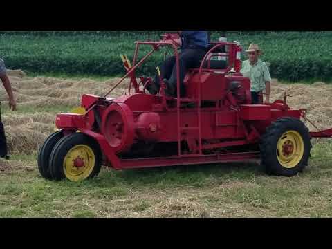 Early model New Holland baling hay, shots of a self-propelled baler ...