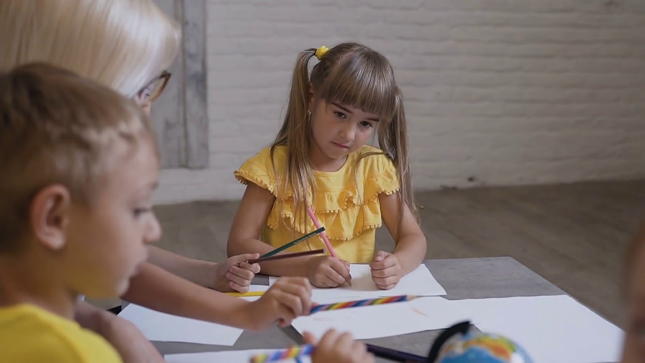 videoblocks a group of children and a teacher draw on white paper using ...