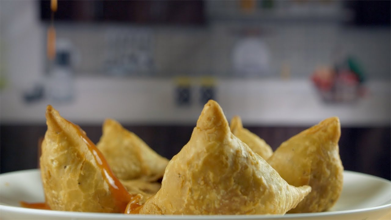 Closeup shot of a samosa plate rotating on a turntable while p ...