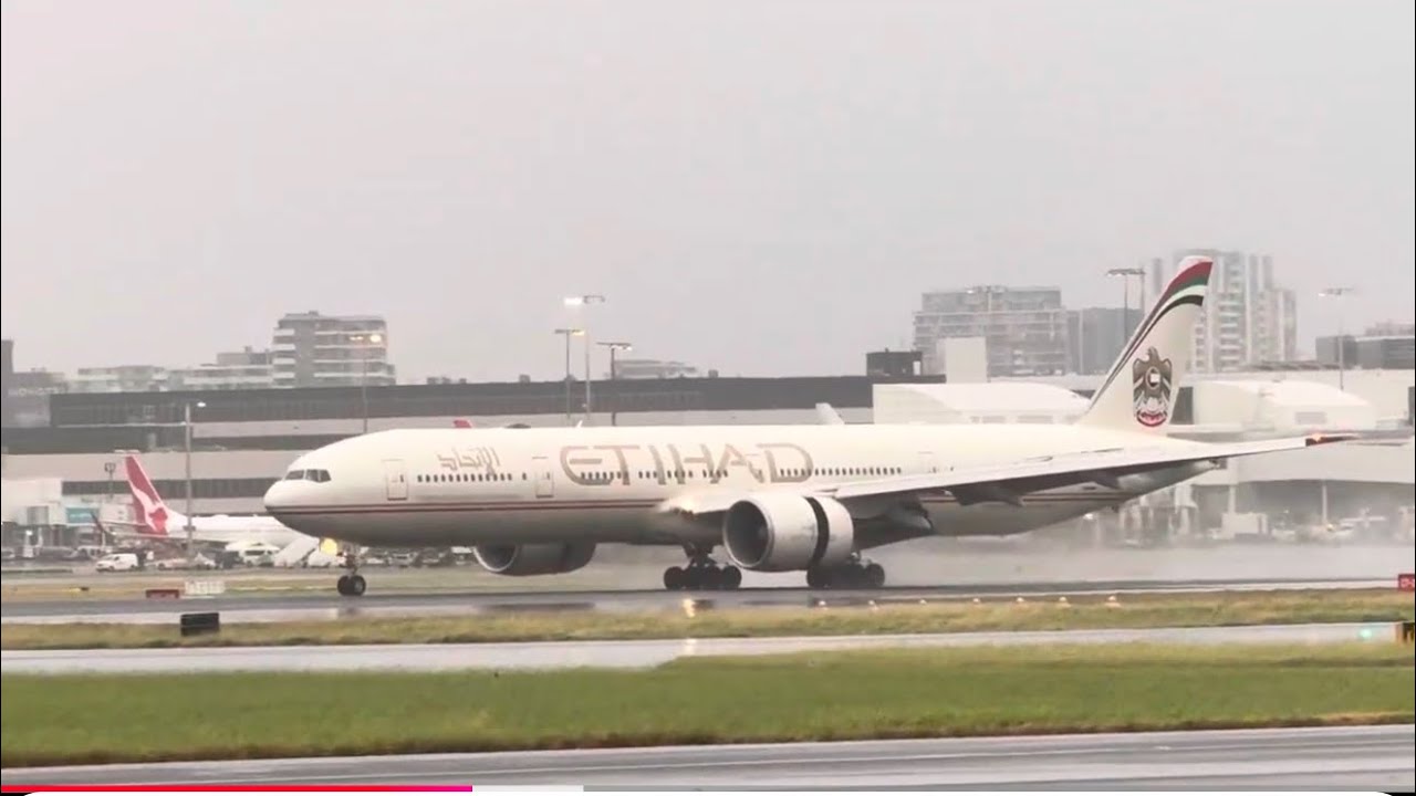 An Etihad Airways B777-300 arrives at a very wet Sydney afternoon on ...