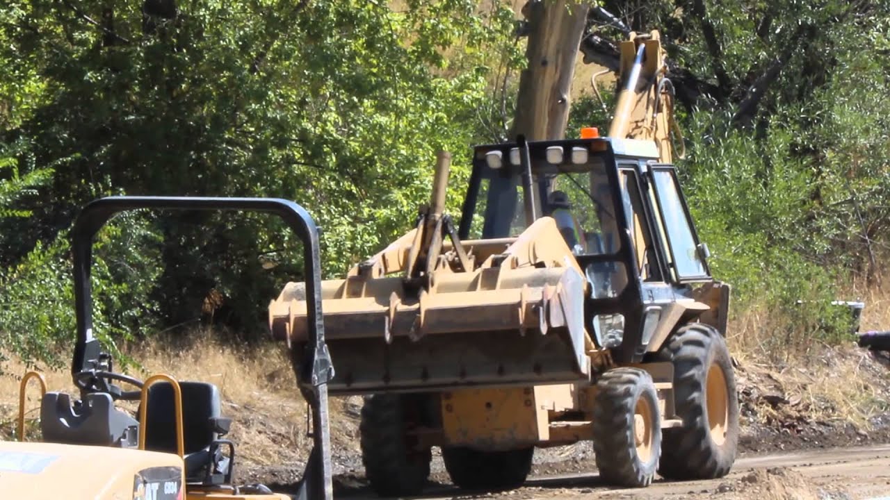 CAT Backhoe driving backwards - YouTube