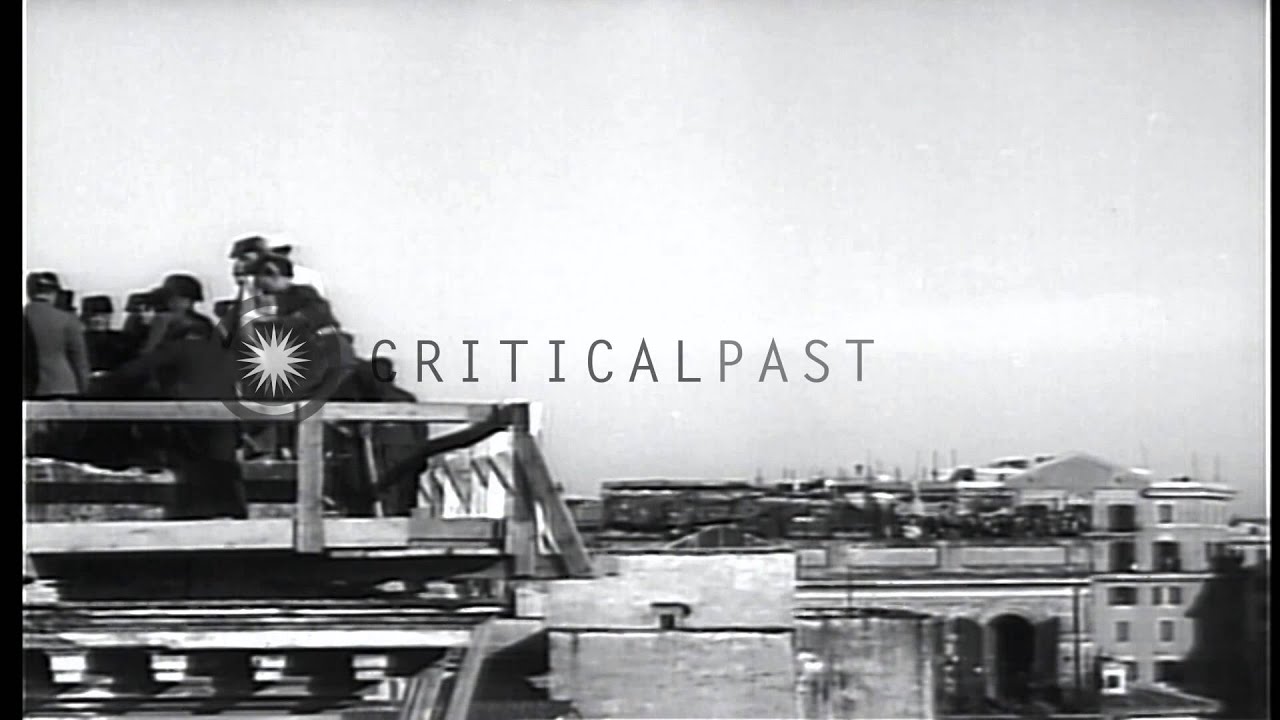 Benito Mussolini, in uniform, helping with manual demolition work on a ...