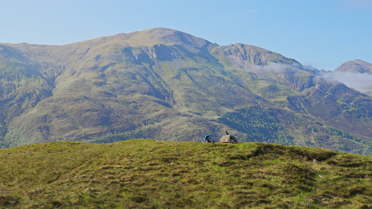 Hikers camping on a mountain ridge in the Scottish Highlands with ...
