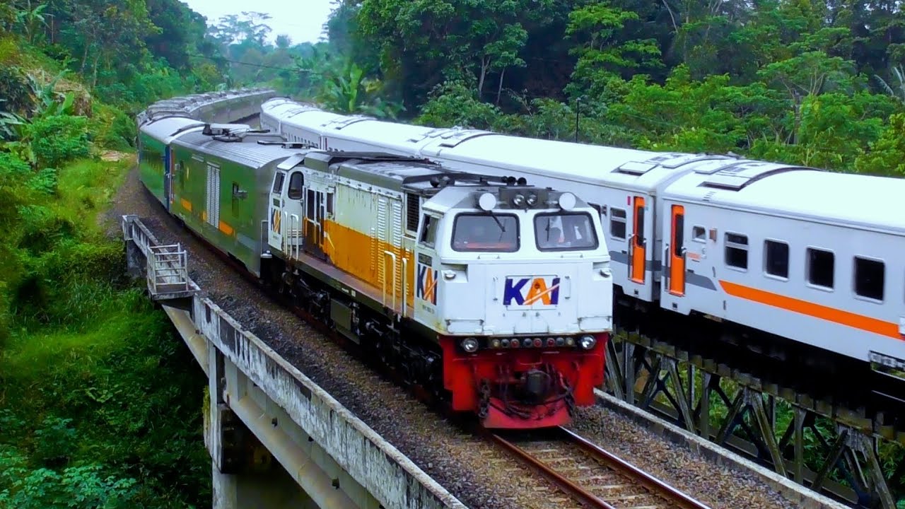 KERETA API PANJANG BERPAPASAN DI ATAS JEMBATAN DENGAN NUANSA ...