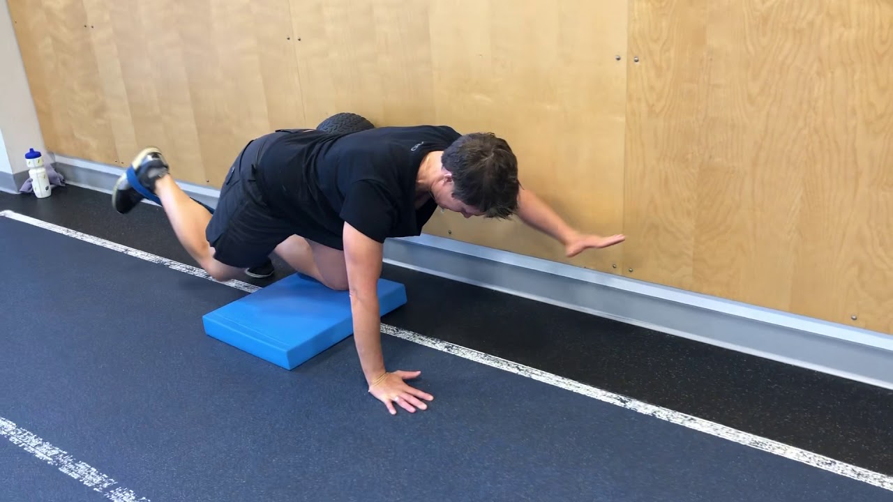 Leg and arm extension with band around feet and ball against wall - YouTube
