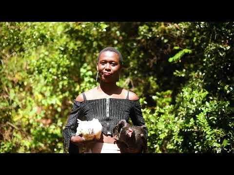 A GIRL SLAUGHTERING CHICKEN FOR FOOD IN BOOTS