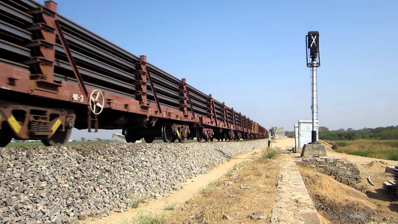 Pune WDG 3A #14810 chugs as it leads a flat bed rake of welded rails ...