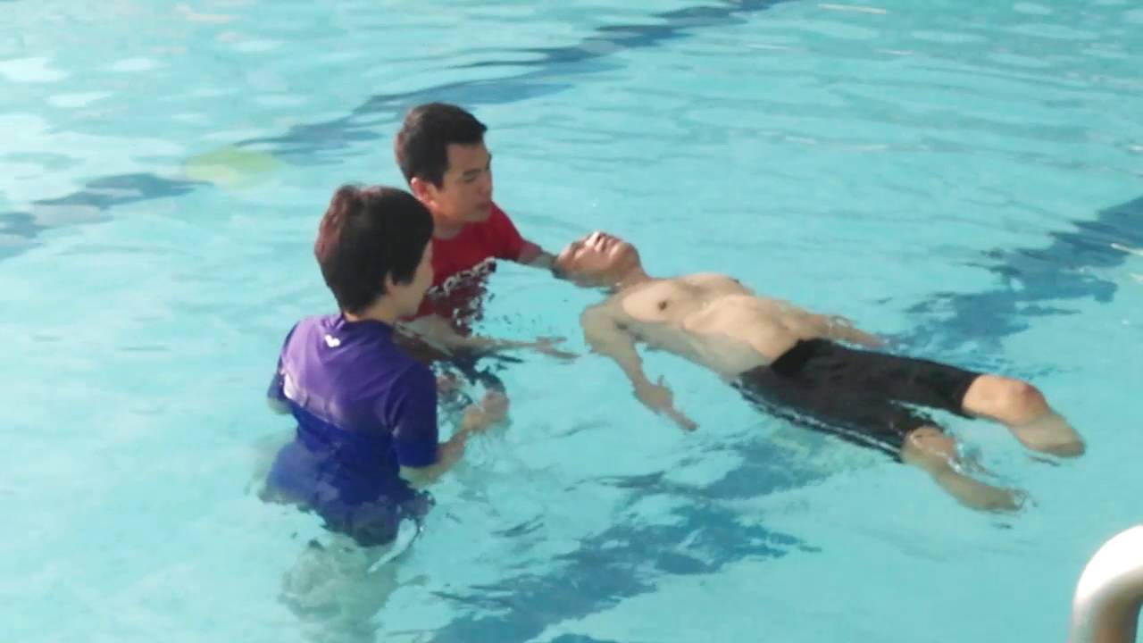Mr Tan Whee Boon in the pool, assisted by coach Danny Ong and Ms Grace ...