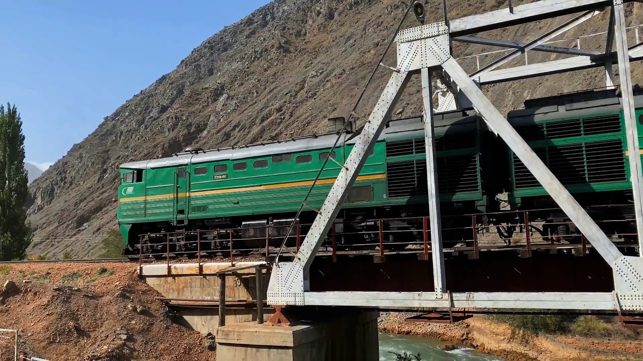 Diesel locomotive 2TE10V-4002 with a freight train crosses a bridge in ...