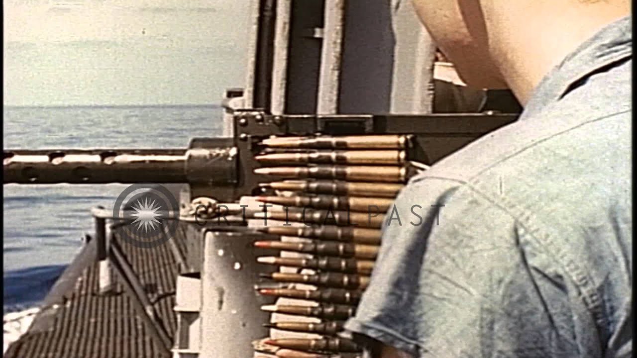 A machine gun aboard a ship being fired at underwater mines in the ...