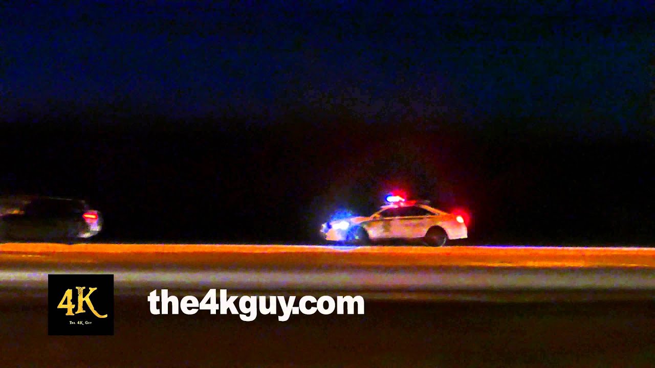 4K UHD - Police car speeding on highway with lights and sirens at night ...