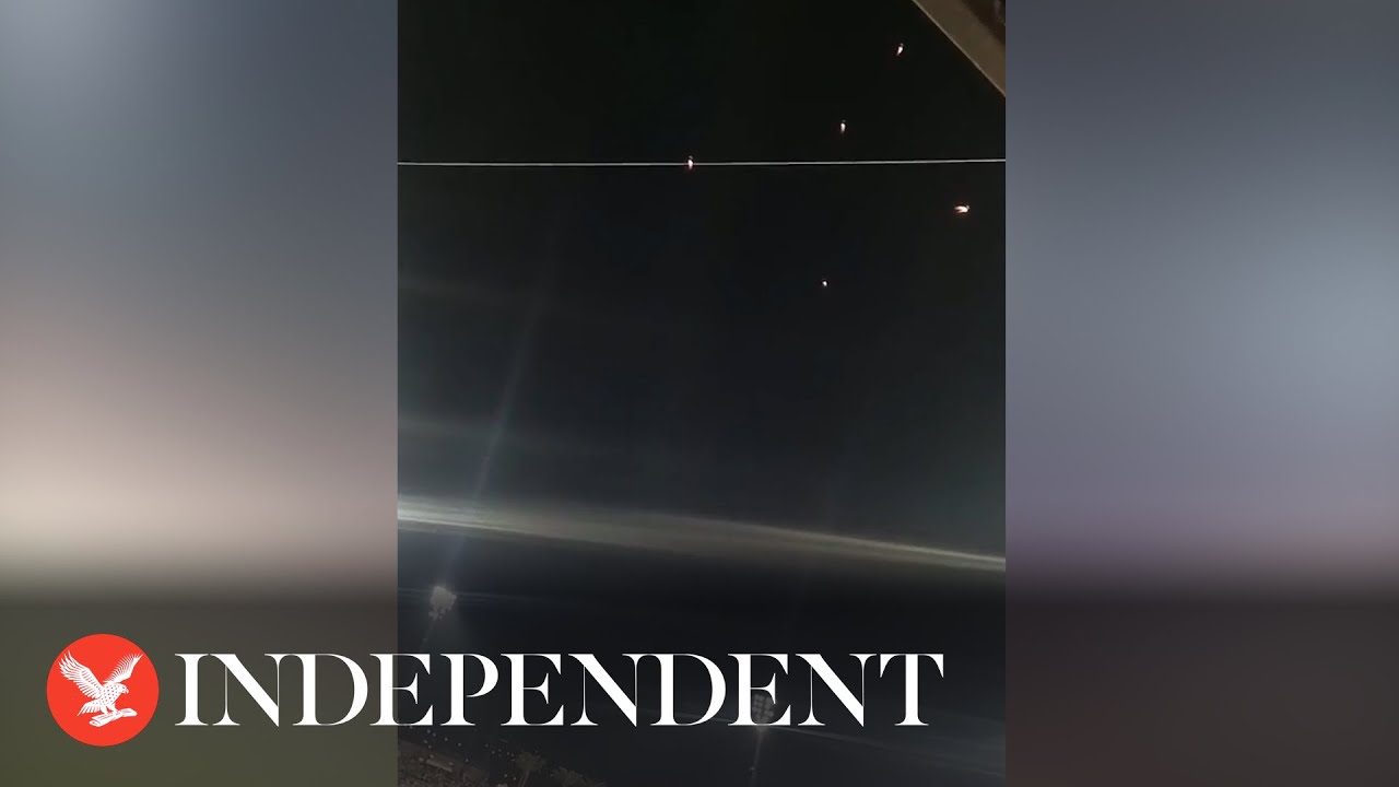 Mysterious glowing objects float in sky above football game in ...