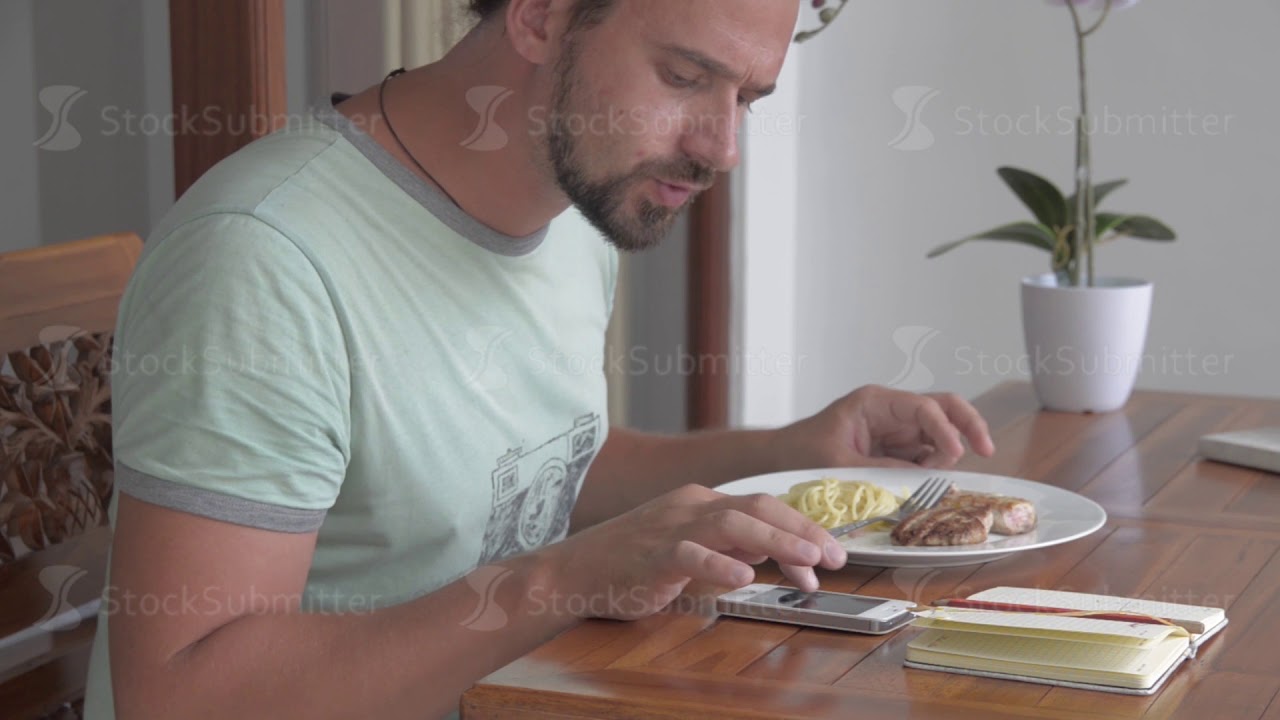 Young man using phone while eating breakfast - YouTube