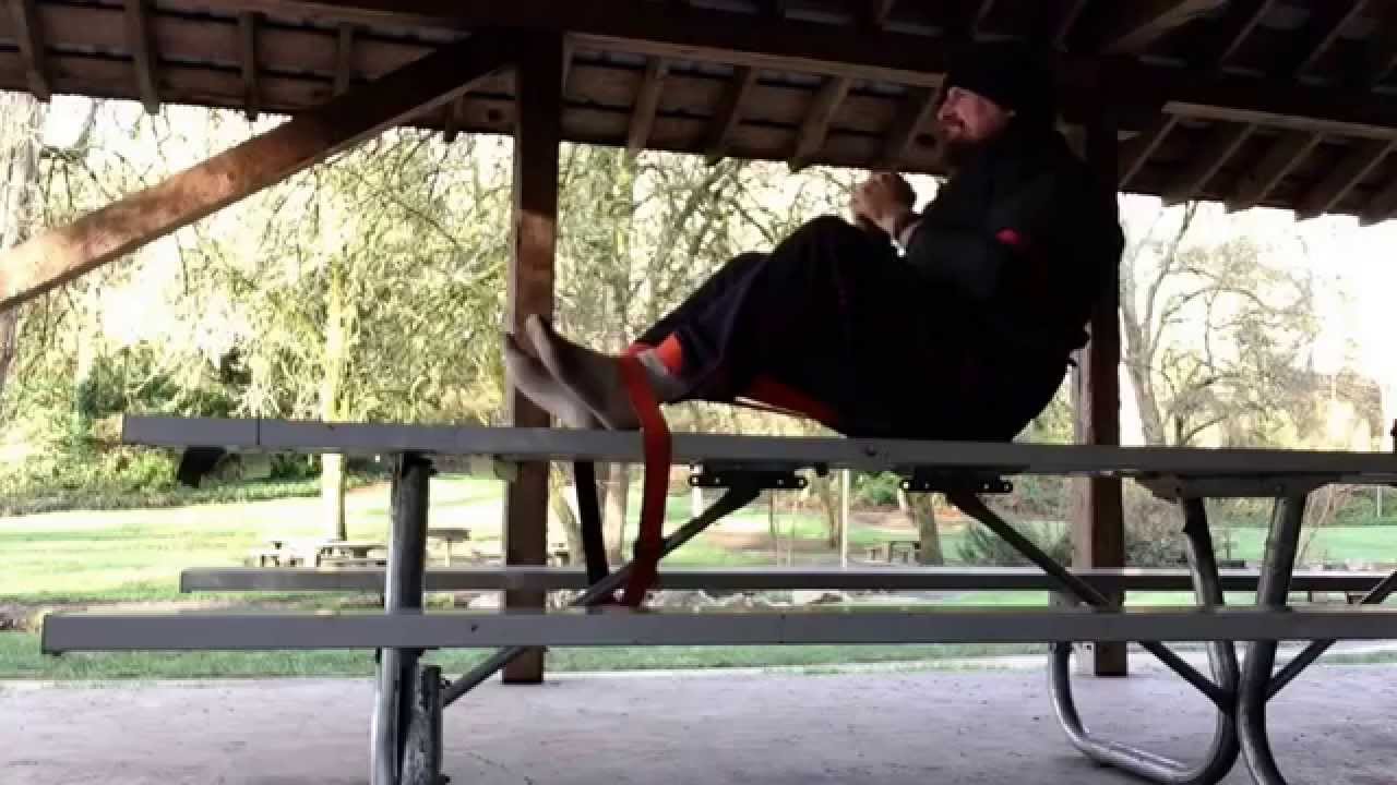 Sit up exercise resistance with the loopy trainer outdoors; picnic ...