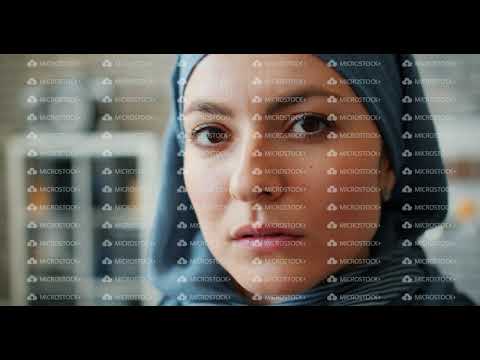 Close-up of attractive Middle Easter lady in hijab looking at camera in office