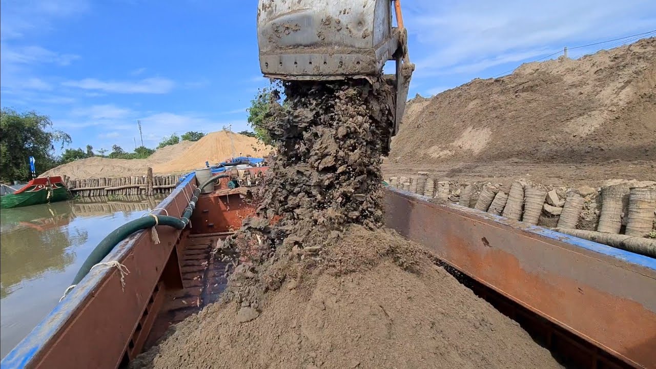 Cạp cát từ bãi xuống xà lan/Scraping sand from the beach to the barge ...
