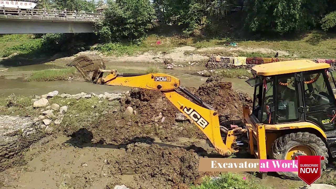 JCB Backhoe Digger busy Digging Mud on Riverside - Heavy Machine ...