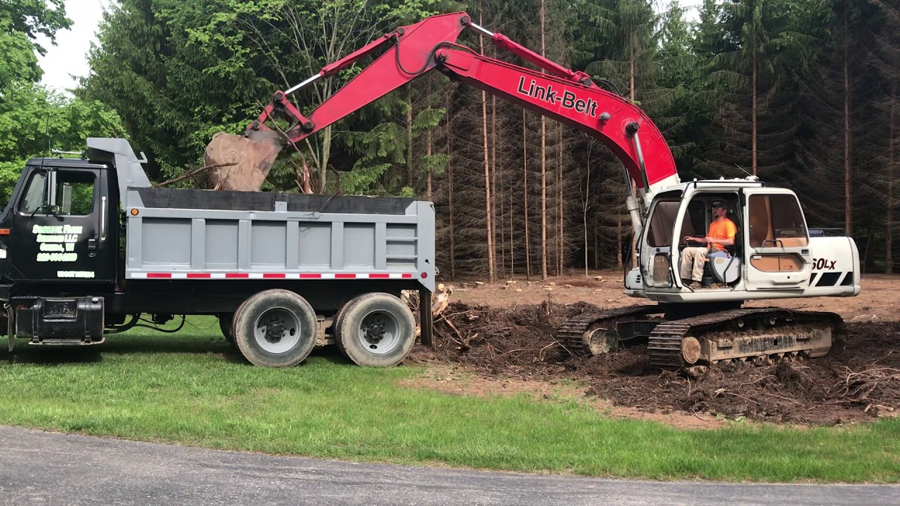 Loading stumps with Link Belt 160 LX onto dump truck - YouTube
