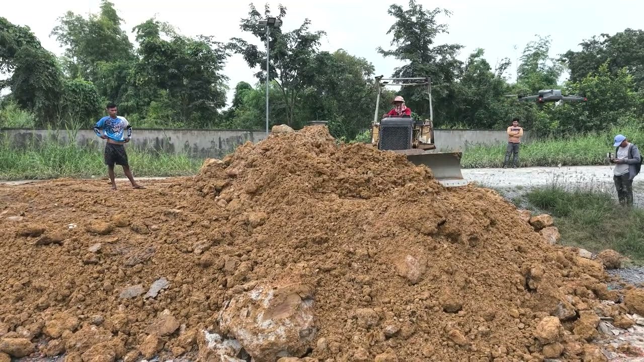 An impressive teamwork step by step bulldozer expertly manipulates soil ...